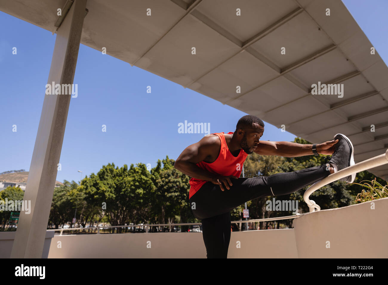 Young man doing exercise under the bridge on railing Stock Photo - Alamy