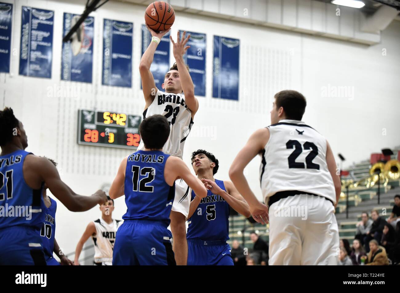 Elevated player firing off a jump shot amidst a group of defending ...