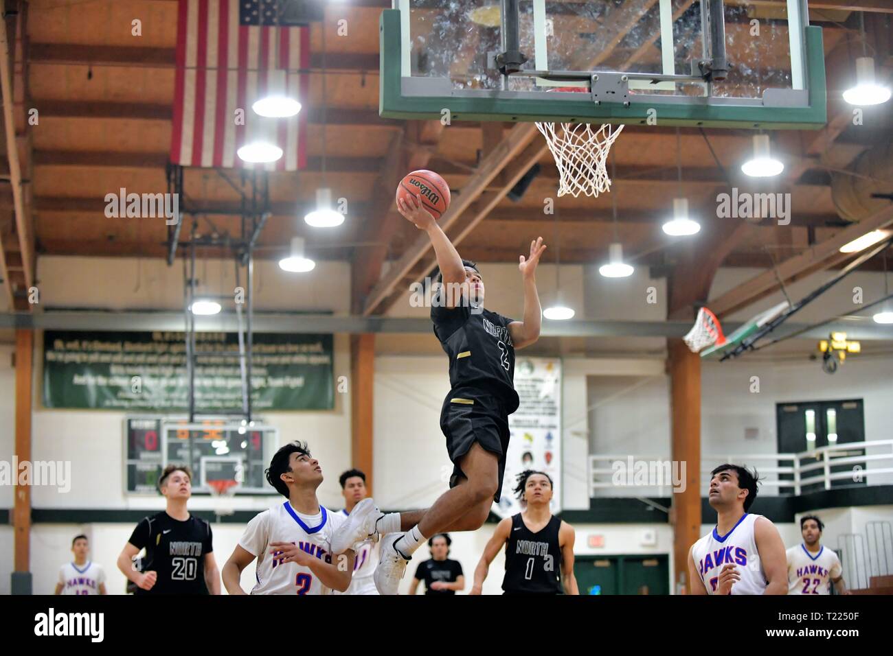 The high flying player taking the ball to the hoop above a crowd on the ...