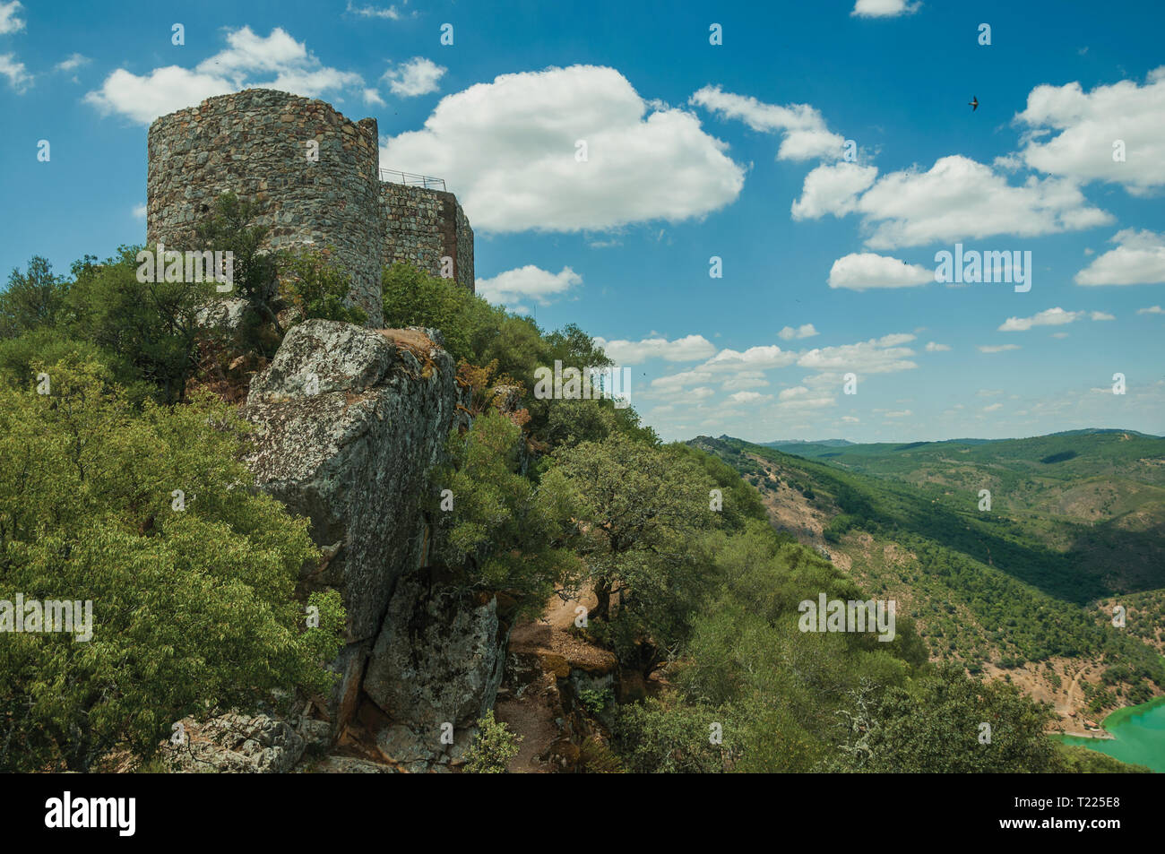 Castle tower on top of rocky cliff covered by trees at the Monfrague ...