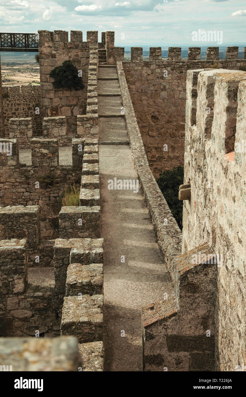 Pathway on top of thick stone wall with crenel and merlons at the ...