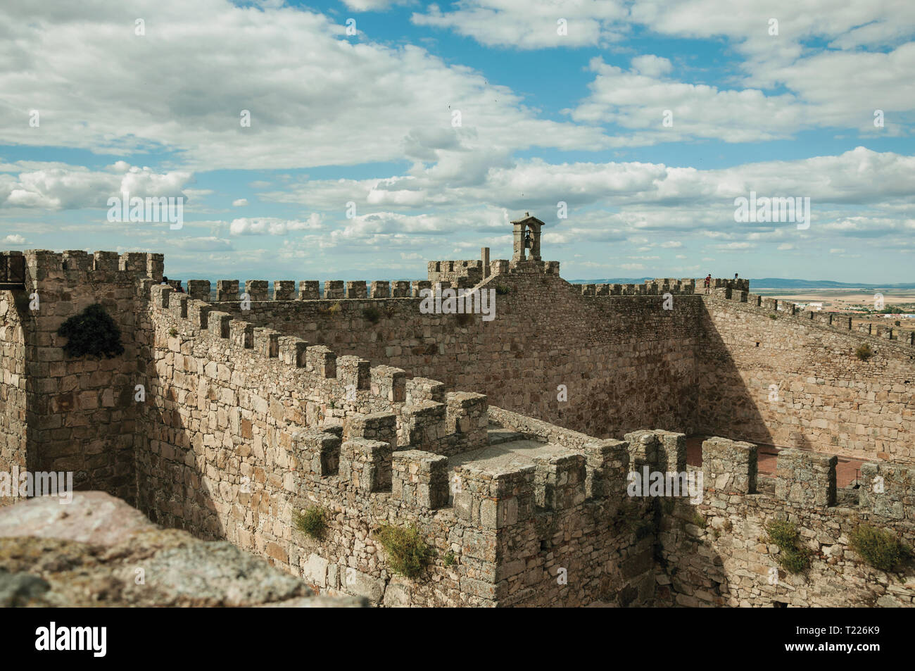 Pathway on top of stone wall with merlons and bell at the Castle of ...