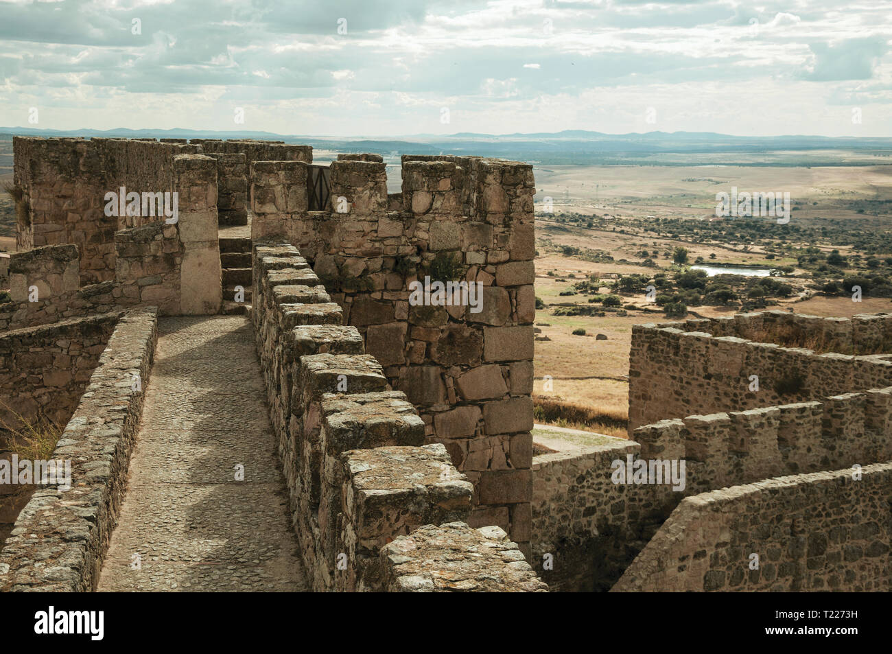 Pathway on top of thick stone wall with merlons at the Castle of ...
