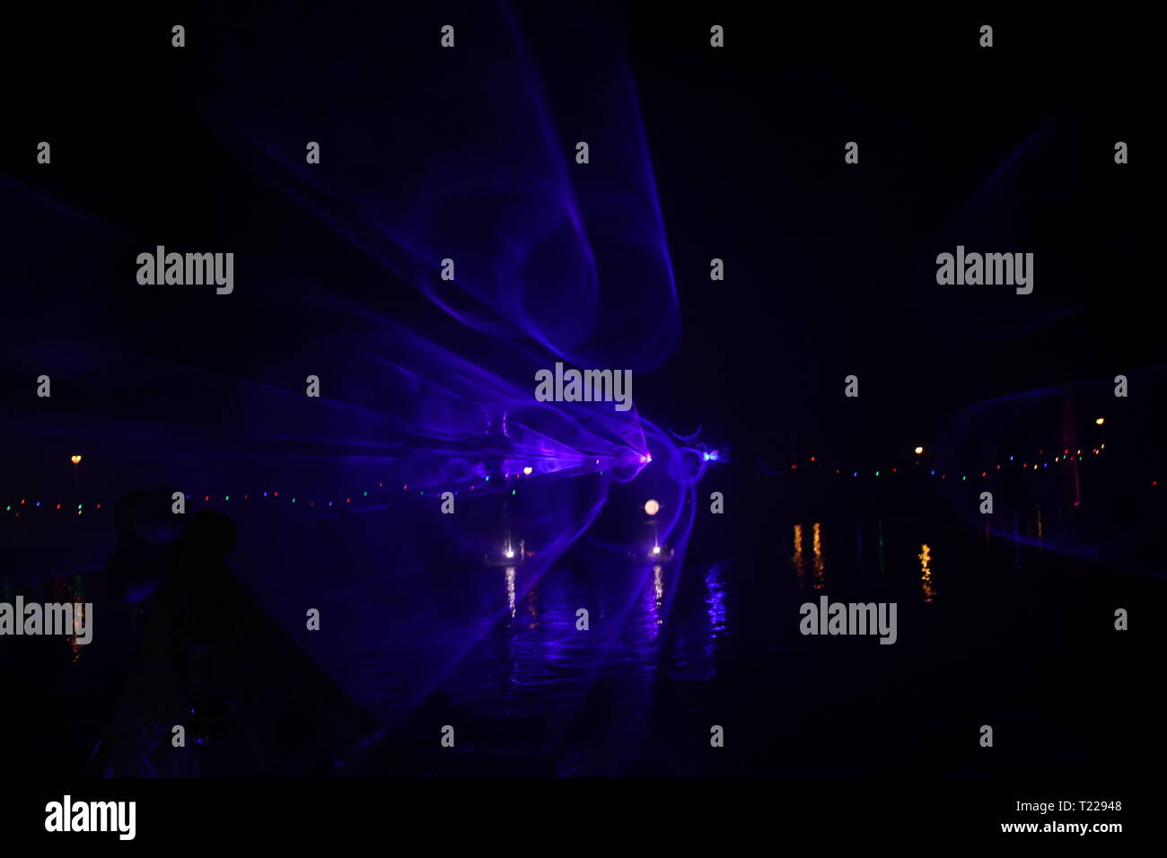 Laser beams during a public show in several colors at the water of the ...