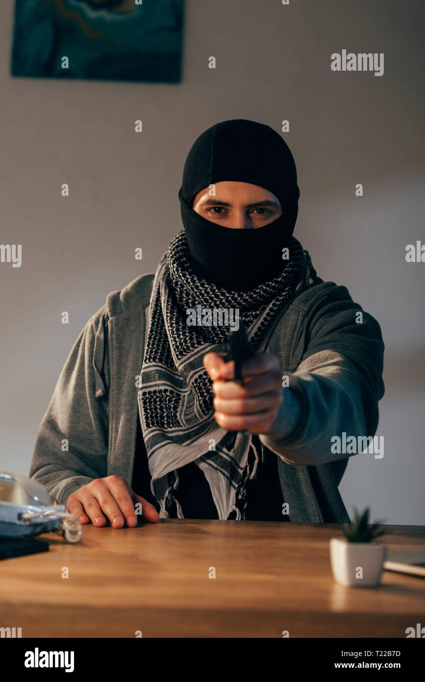 Criminal in black mask and scarf aiming gun at camera Stock Photo - Alamy