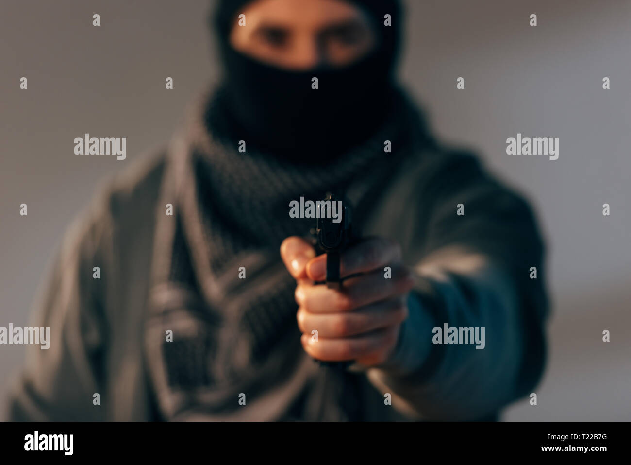 Terrorist in mask and scarf aiming gun at camera Stock Photo - Alamy