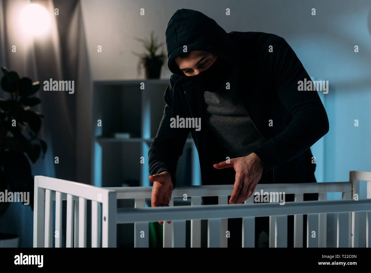 Criminal in mask and black clothes kidnapping child from crib Stock ...