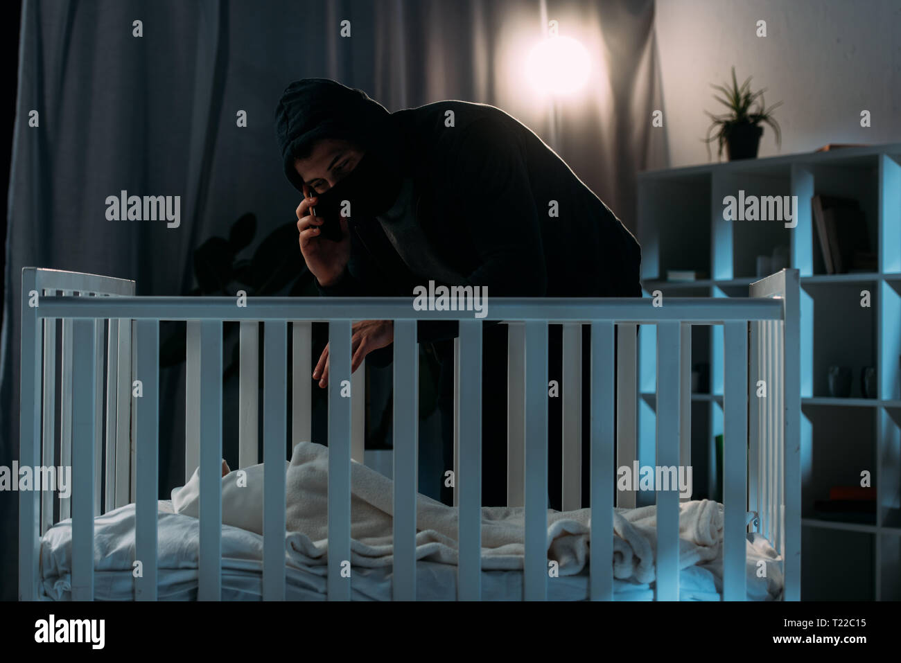 Criminal in mask talking on smartphone while kidnapping child Stock ...