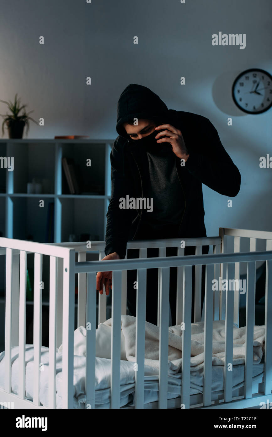 Criminal in mask talking on smartphone while kidnapping child Stock ...