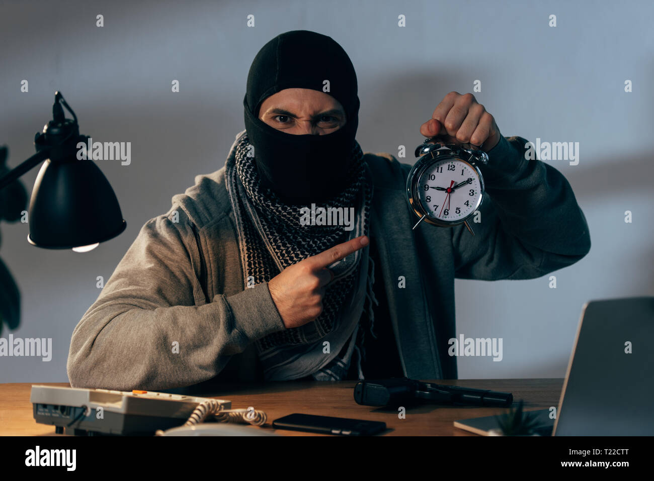 Angry terrorist in black mask pointing with finger at alarm clock Stock ...
