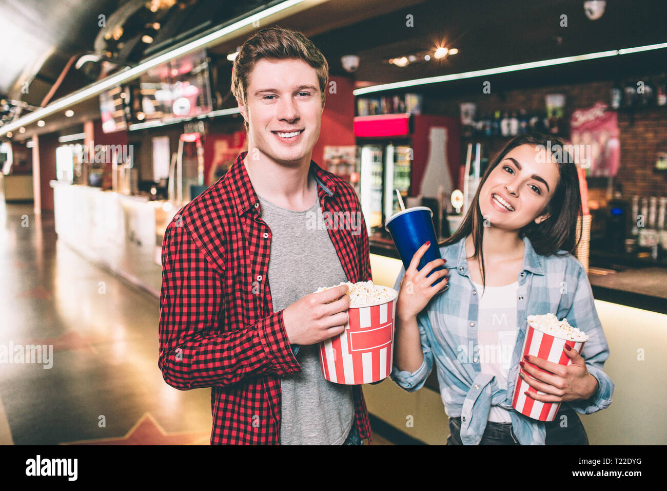 Handsome guy and beautiful girl are posing. They are looking straight ...