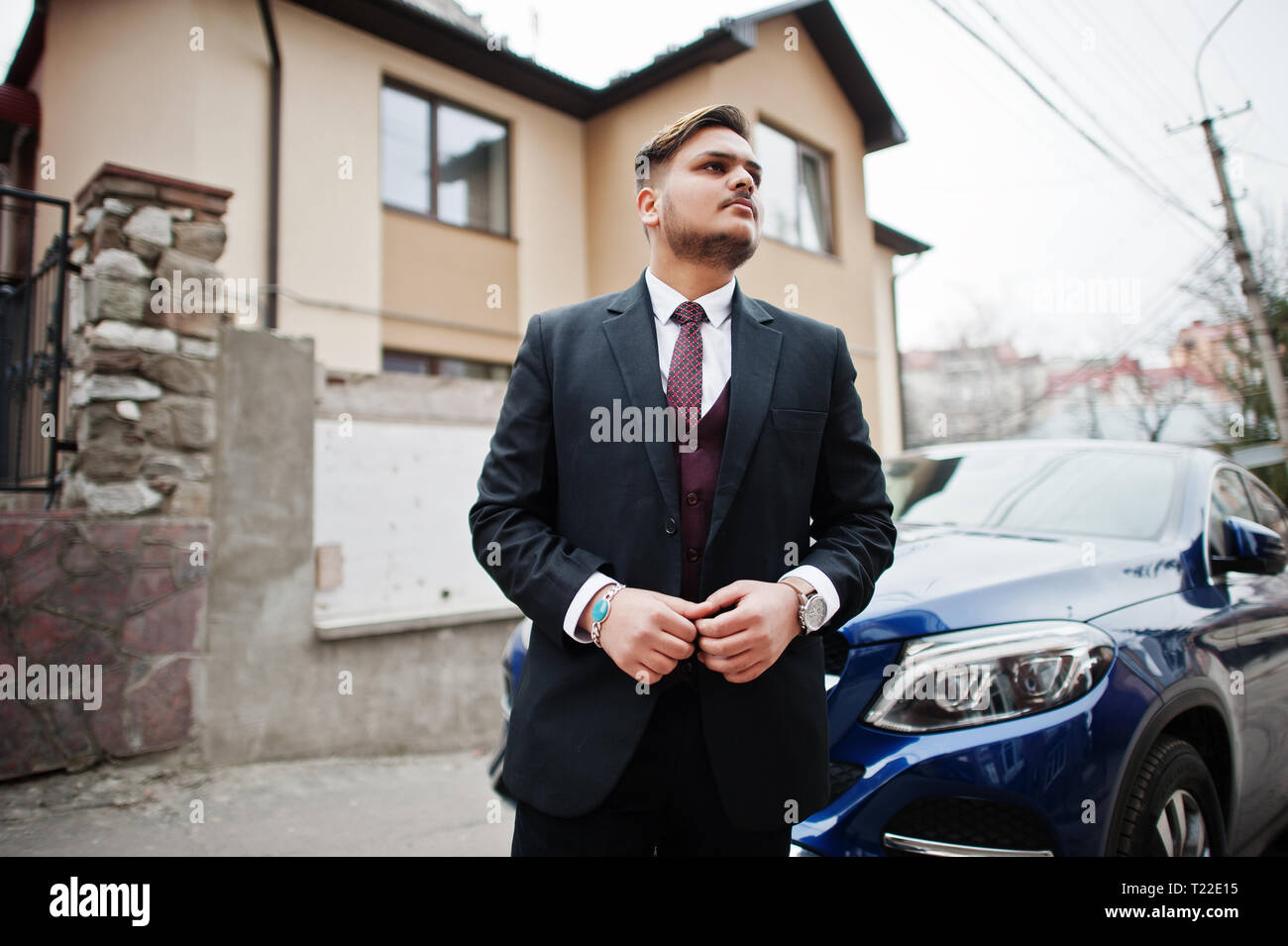Rich indian businessman in formal wear standing against business suv ...