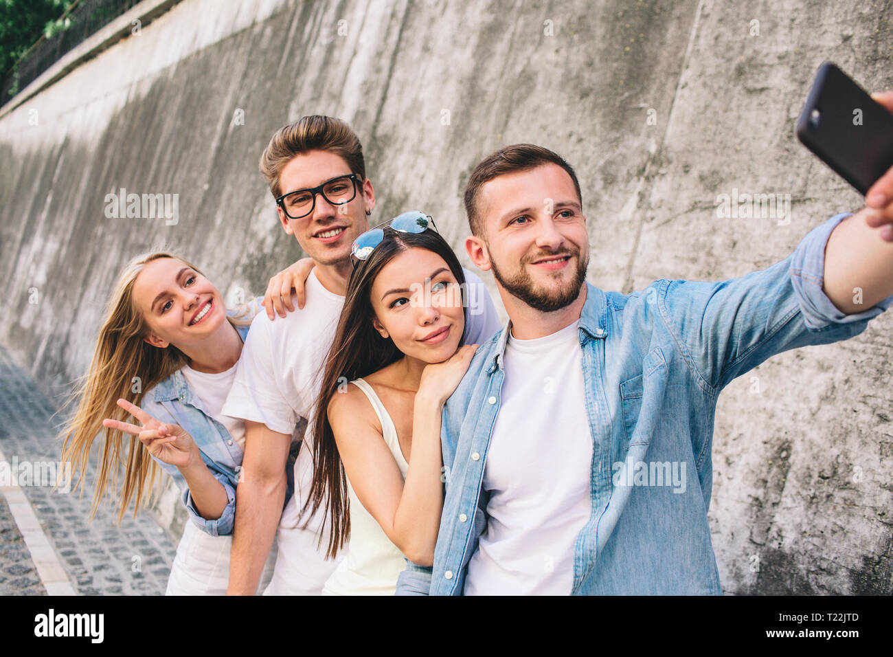 Bearded handsome man is standing in front of his friends and taking ...