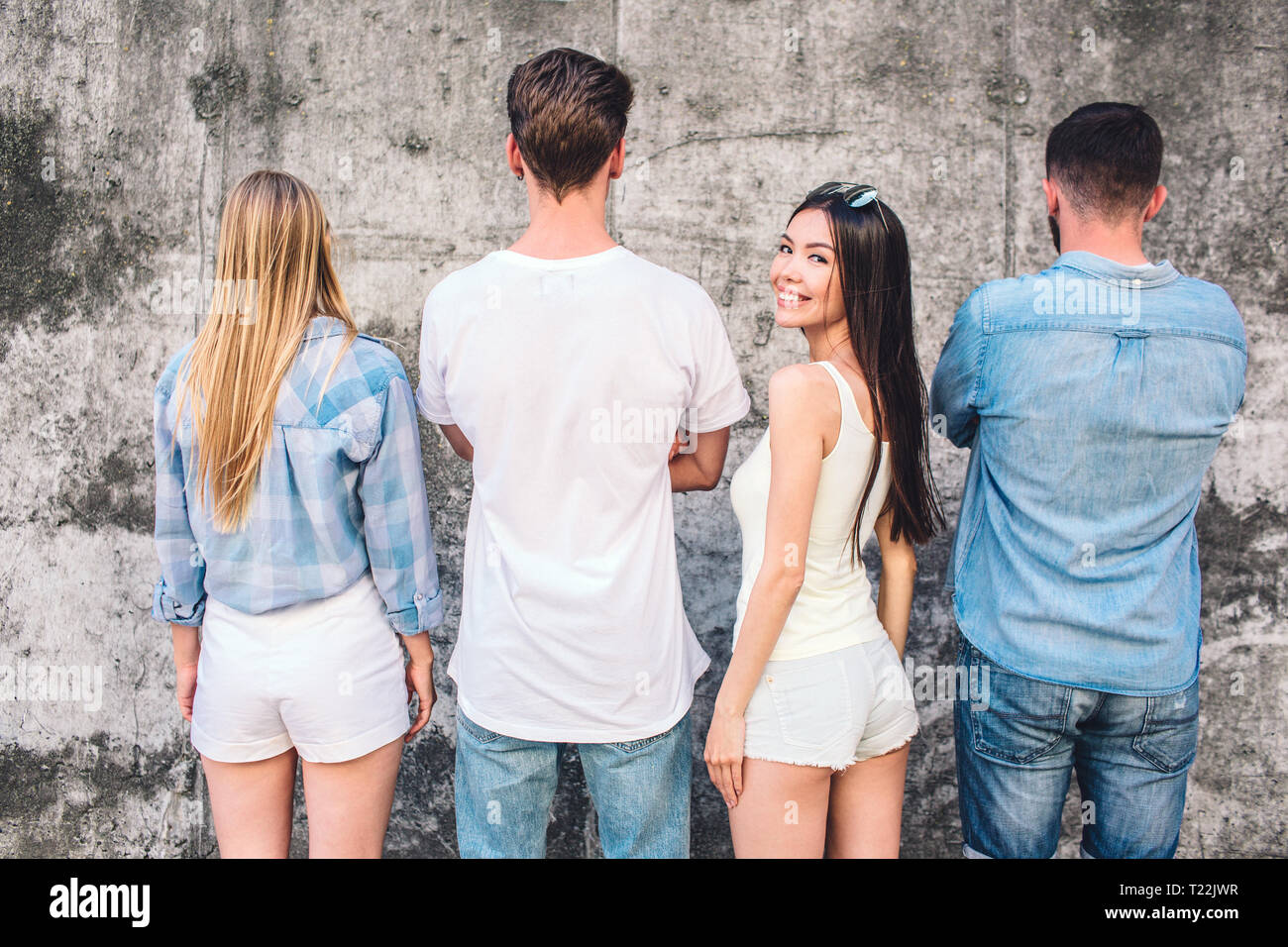 Happy chinese girl is looking backwards on camera and smiling. She is ...