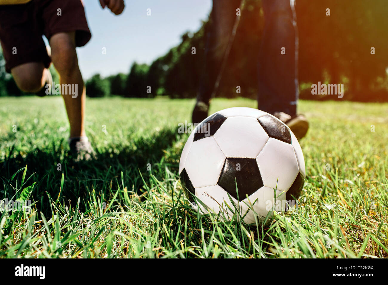 A picture of legs of two people playing football game. They are playing ...