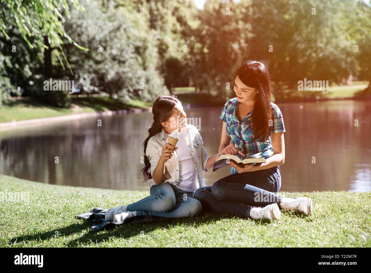 A picture of two attractive person sitting together on grass at the ...