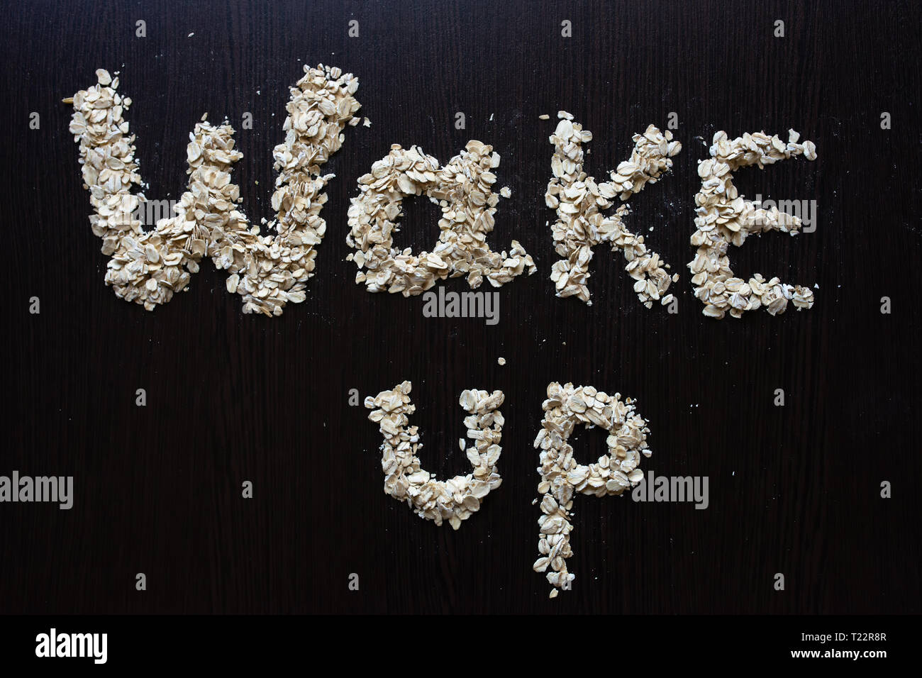 letters of oatmeal lined with words Wake up on the background of a dark ...