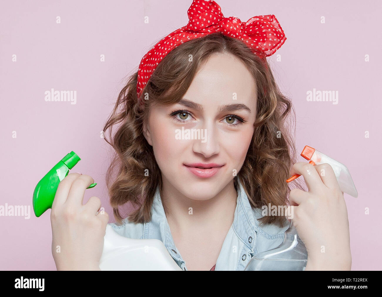 Beautiful young woman with pin-up make-up and hairstyle with cleaning ...