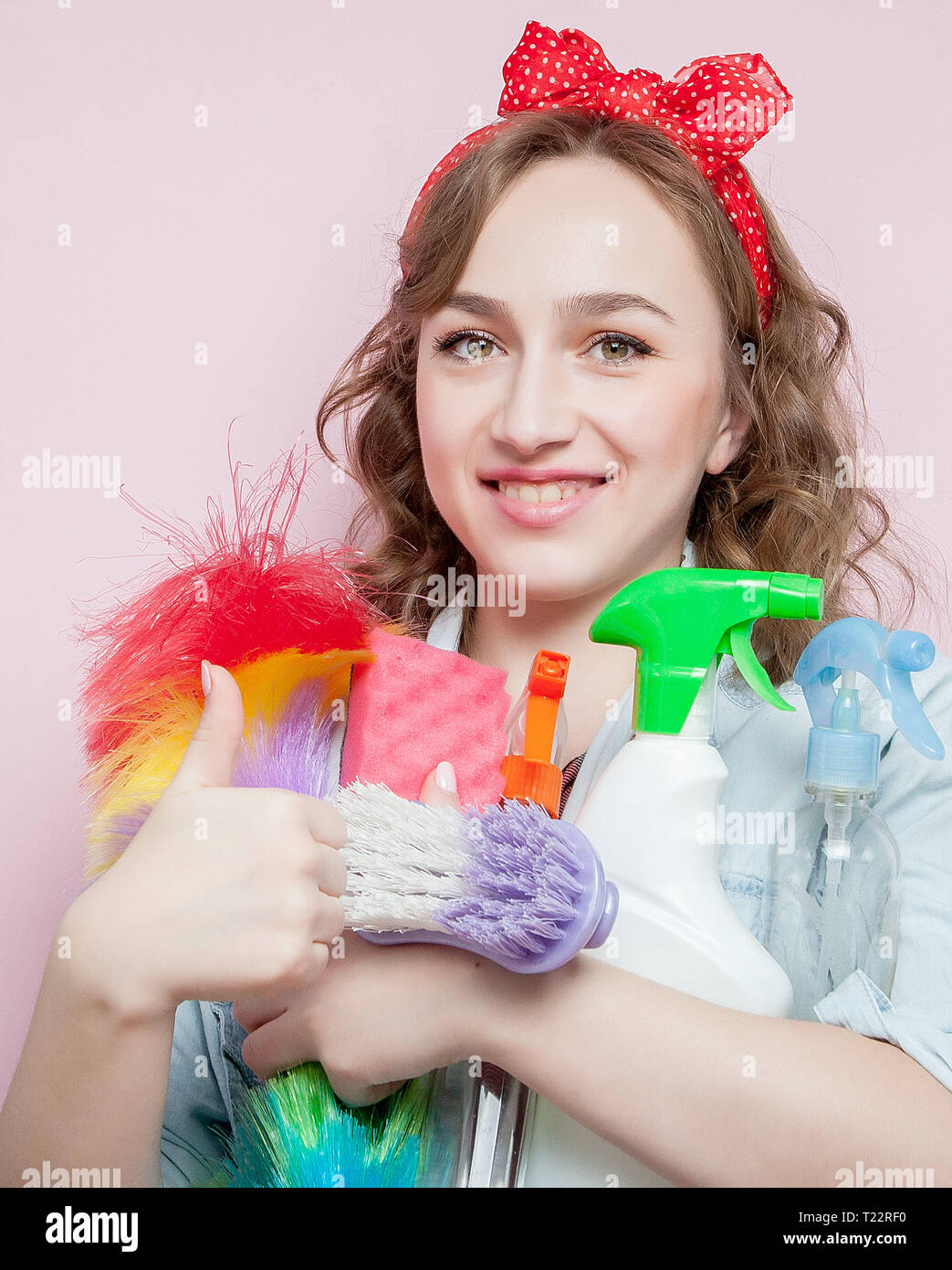 Beautiful young woman with pin-up make-up and hairstyle with cleaning ...