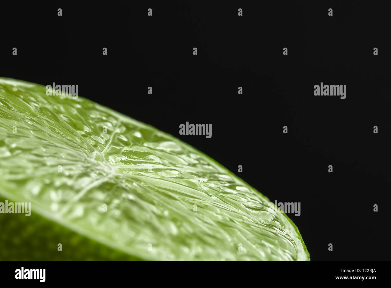 Half a juicy lime. Isolate on black background. Side view. Macro Stock ...