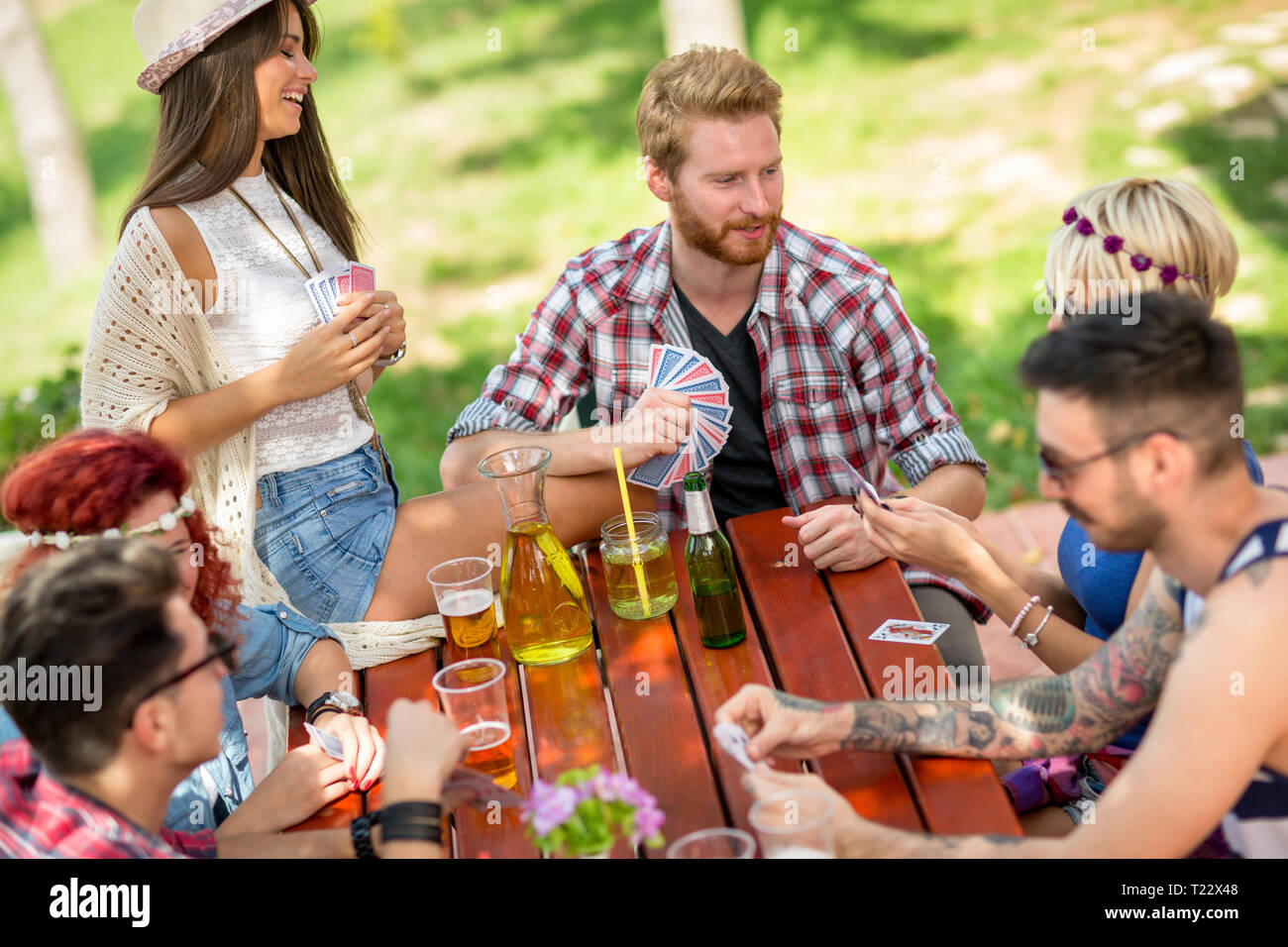 Playing cards outdoor with friends and drinks in nature is enjoyment ...