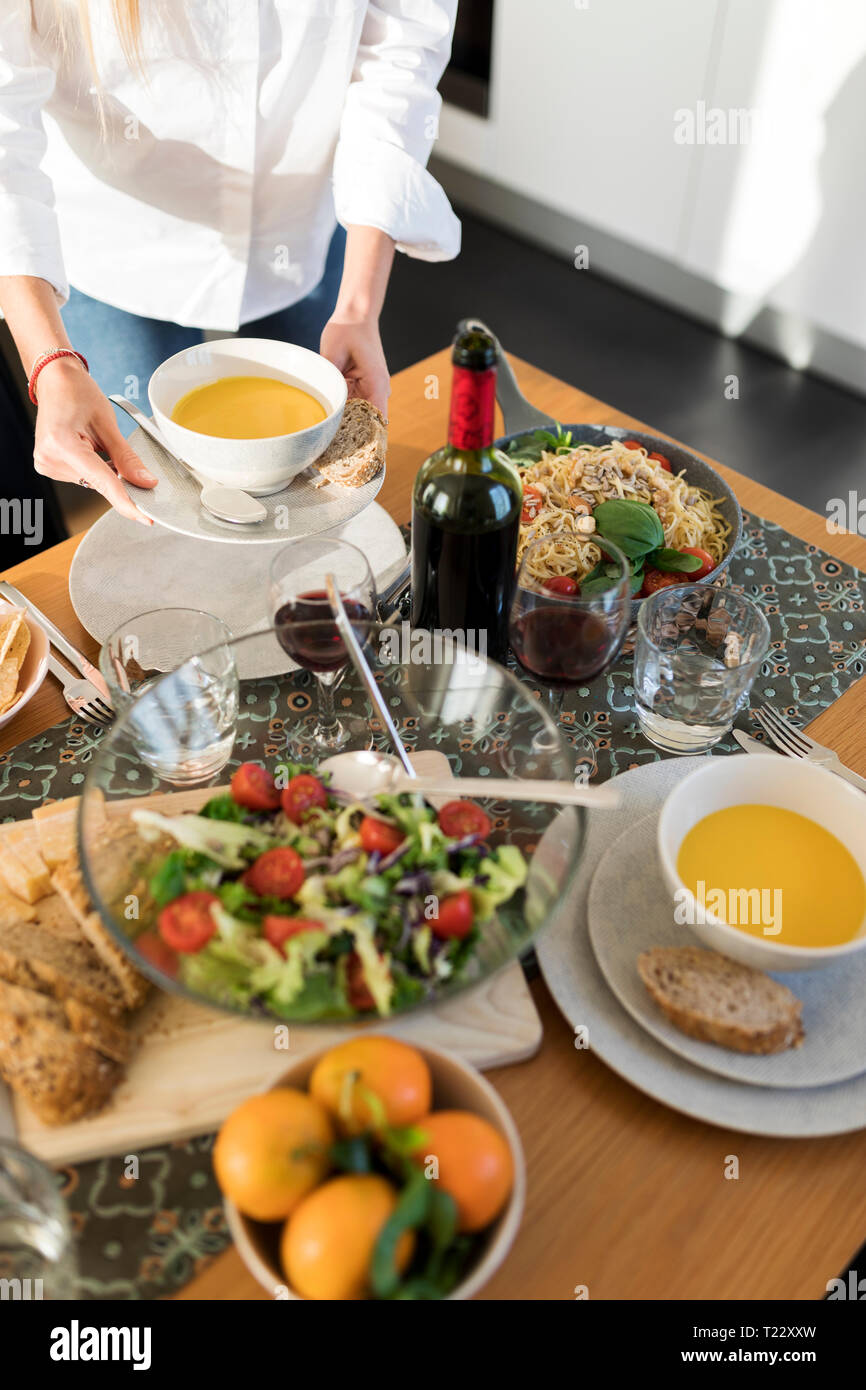 Young woman preparing table for lunch with friends Stock Photo - Alamy