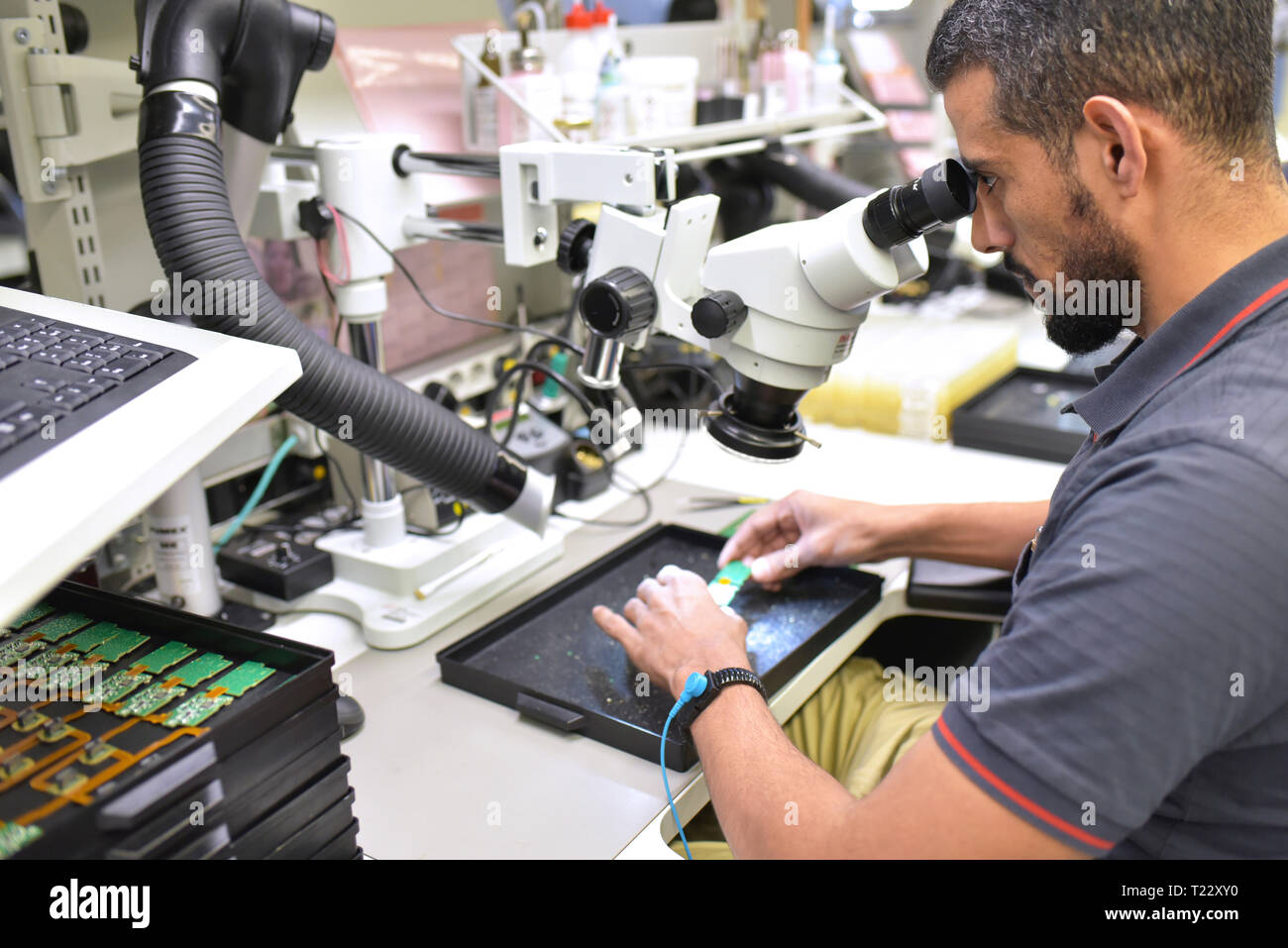 Man using a microscope for the quality control in the manufacturing of ...