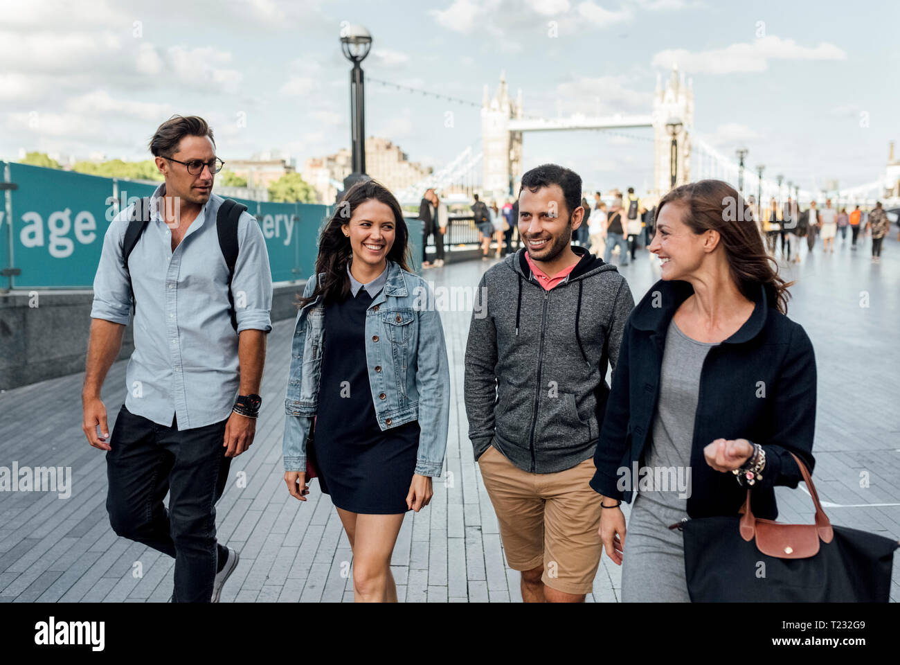 Happy friends walking near tower bridge hi-res stock photography and ...