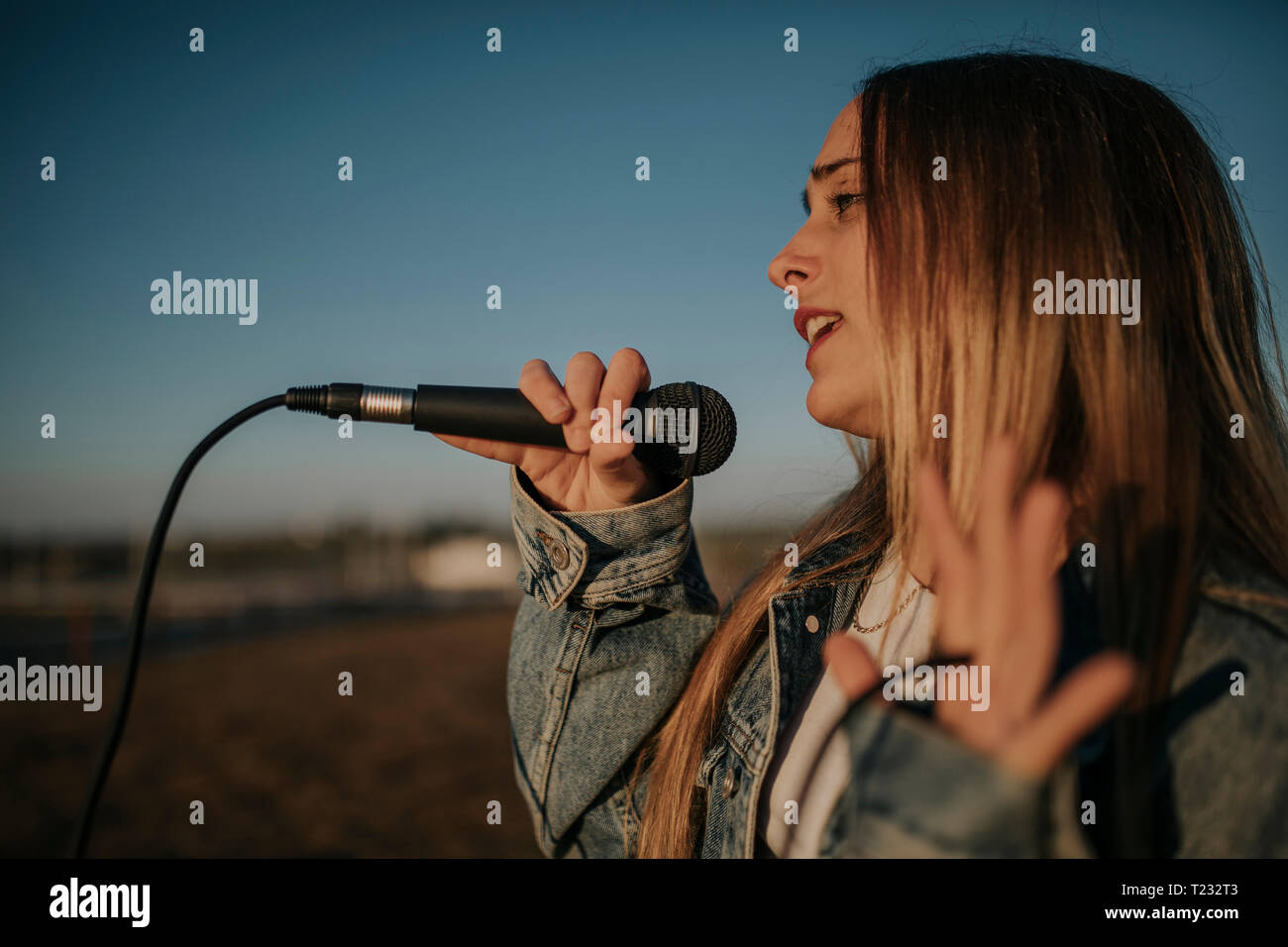 Woman singing into microphone hi-res stock photography and images - Alamy