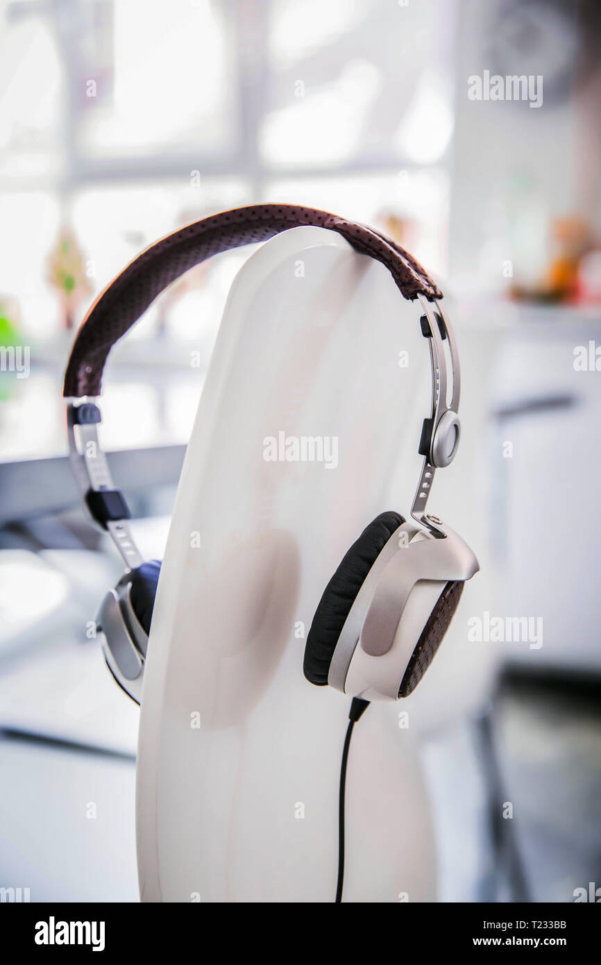 Headphones hanging on back rest Stock Photo - Alamy