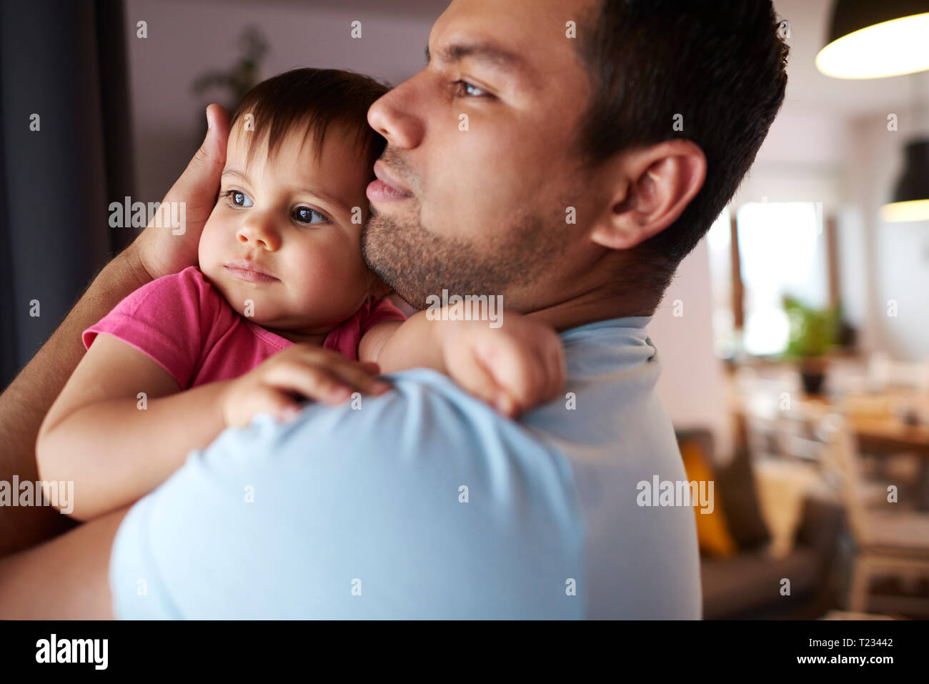Affectionate father hugging his baby daughter at home Stock Photo - Alamy