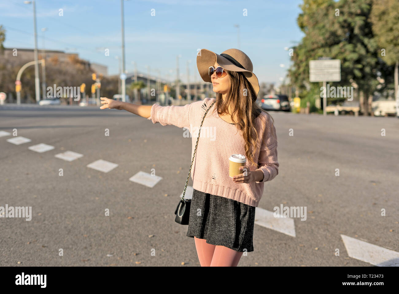 Young woman commuting in the city, hailing a taxi Stock Photo - Alamy