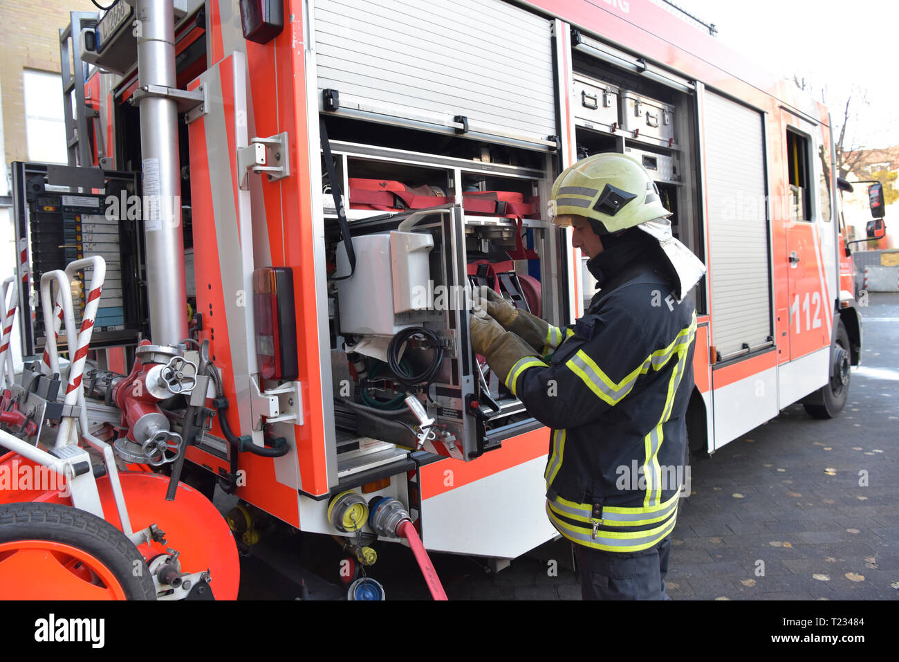 Firefighter standing at fire engine Stock Photo - Alamy