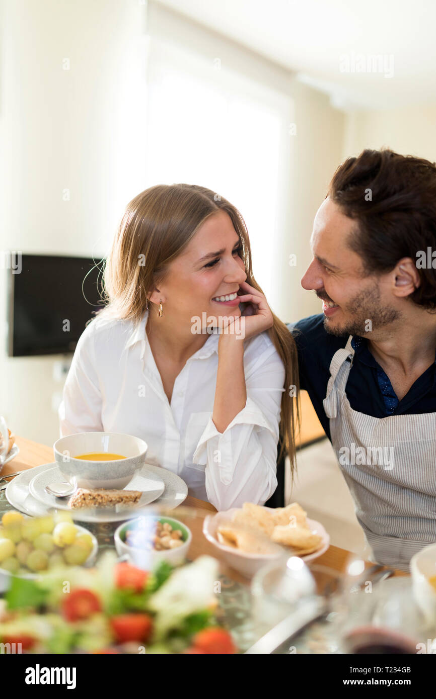 Friends having fun, eating lunch together, couple flirting at the table ...