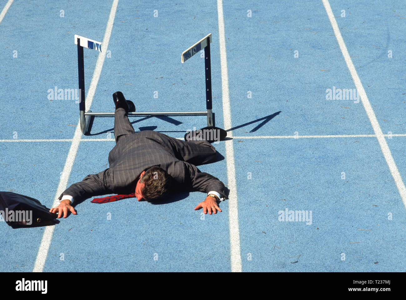 Mature businessman fallen over hurdle on running track, USA Stock Photo ...