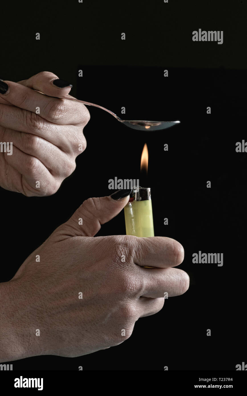 Heating heroin in spoon Stock Photo - Alamy