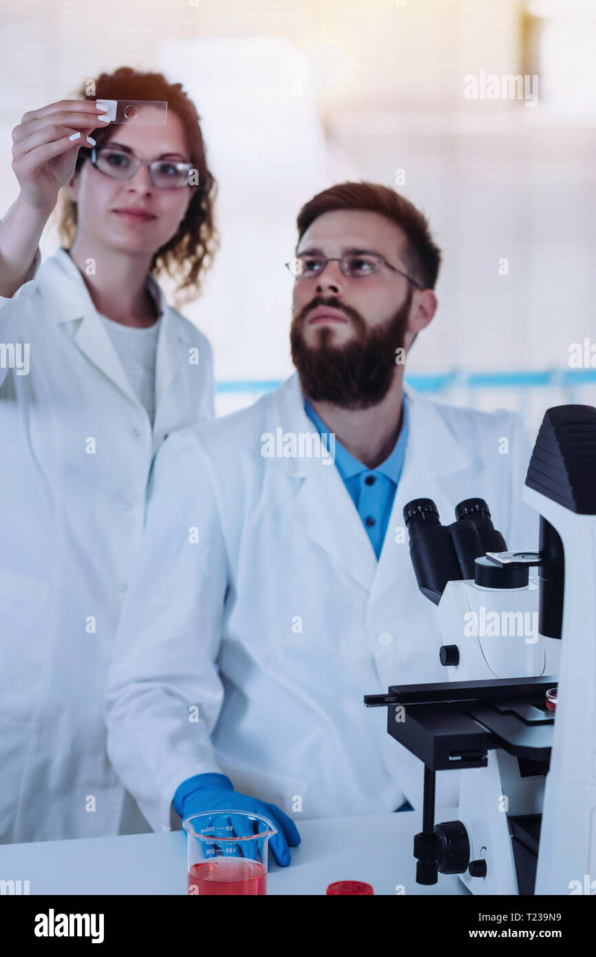 Young students observing slide in laboratory Stock Photo - Alamy