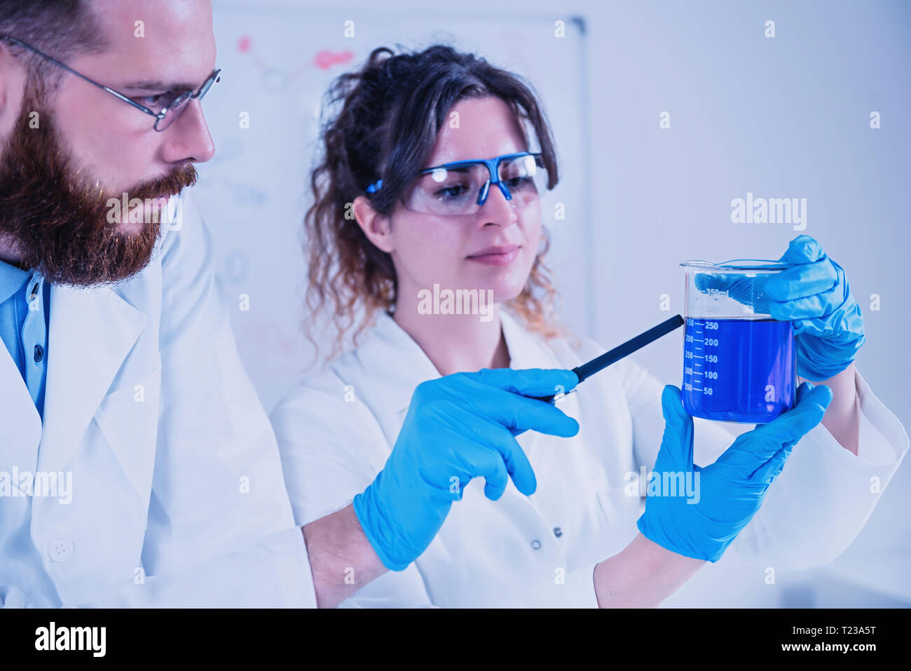 Young scientist doing experiments in the laboratory, wearing safety ...
