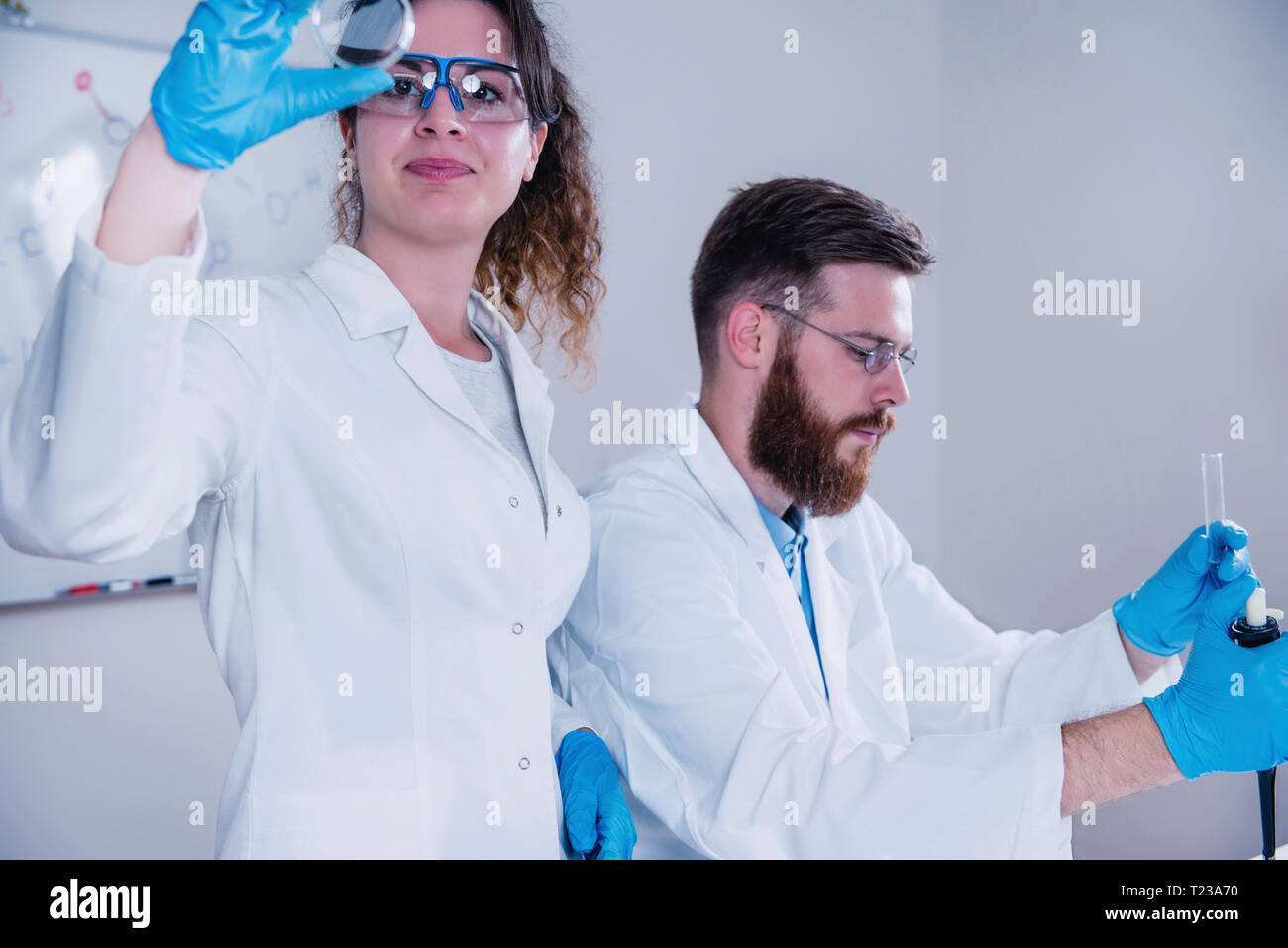 Young scientist doing experiments in the laboratory, wearing safety ...