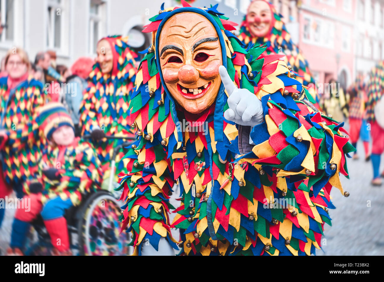 Colorful carnival figure with pretty wooden mask shows a gesture with ...