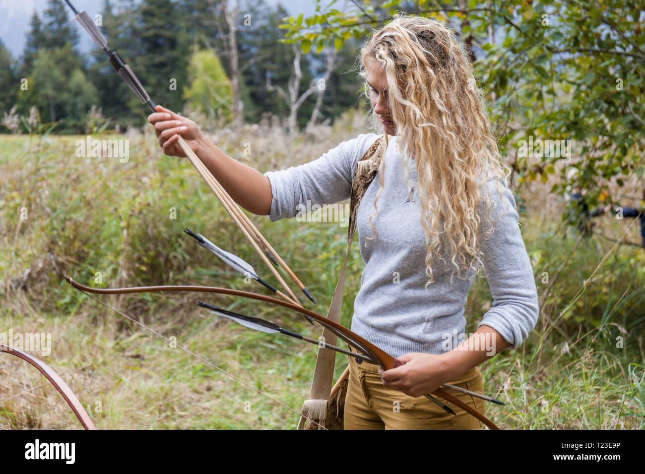 Archeress sorting bow and arrows in nature Stock Photo - Alamy