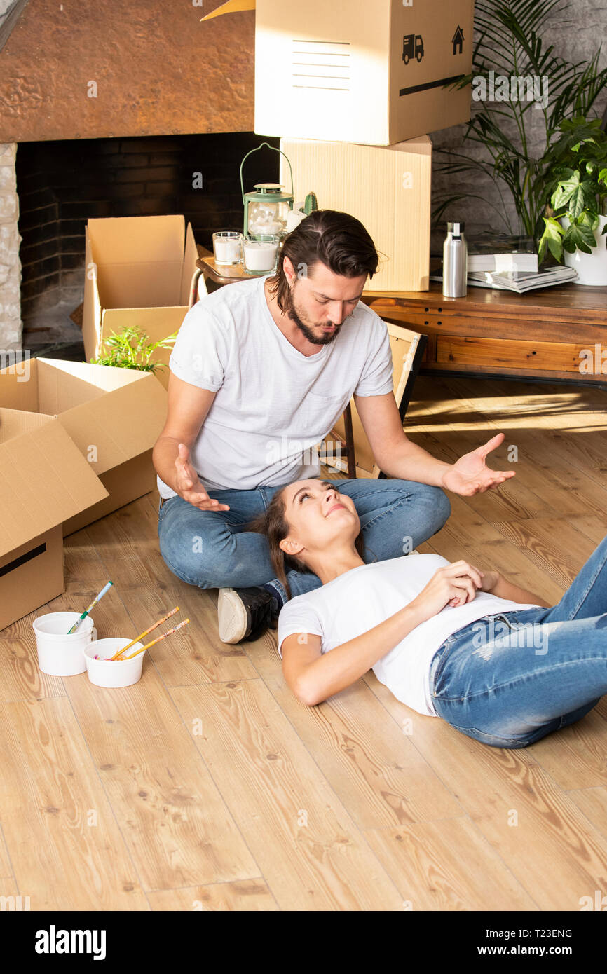 Couple with cardboard boxes in new home having a break Stock Photo - Alamy