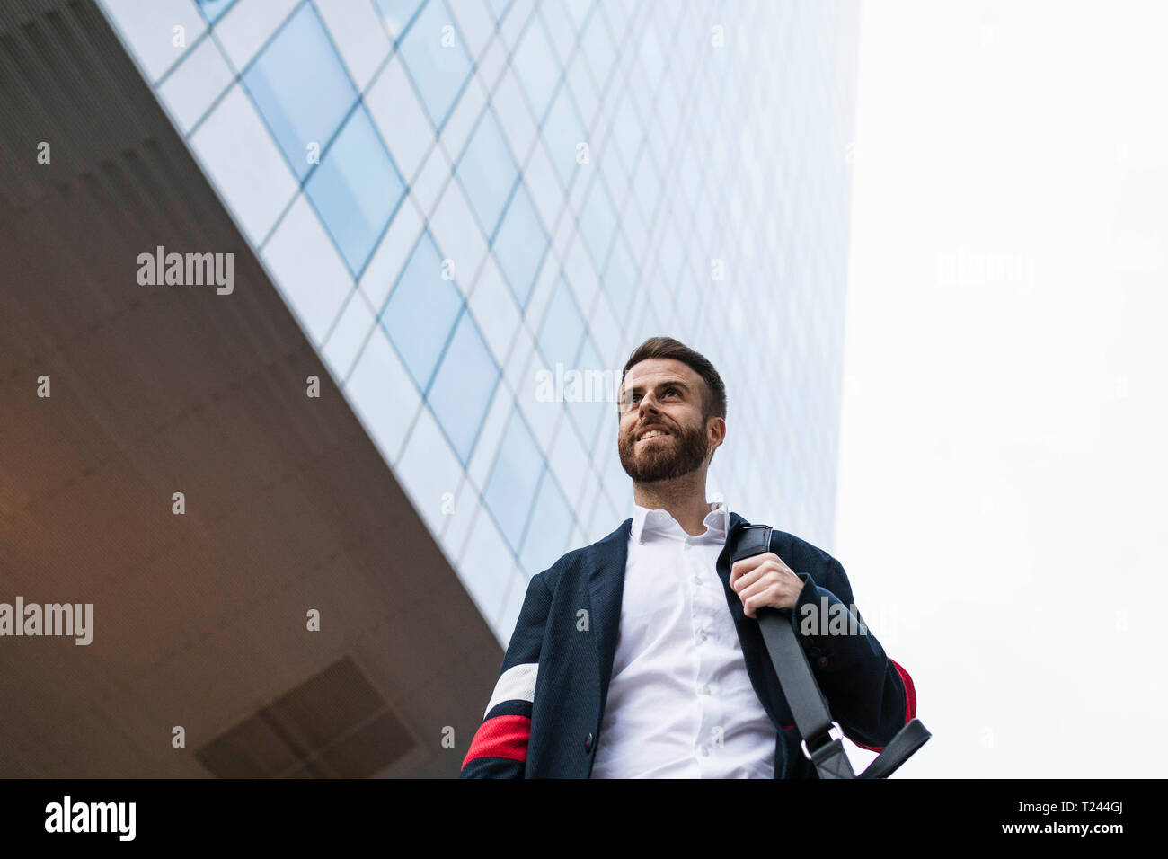 Stylish businessman in front of office building looking around Stock ...