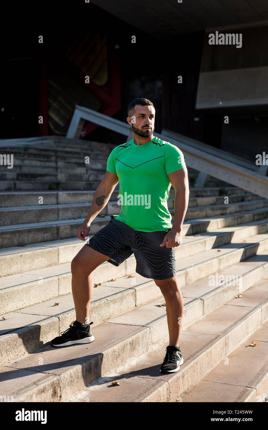 Sportive man during workout, standing on steps Stock Photo - Alamy
