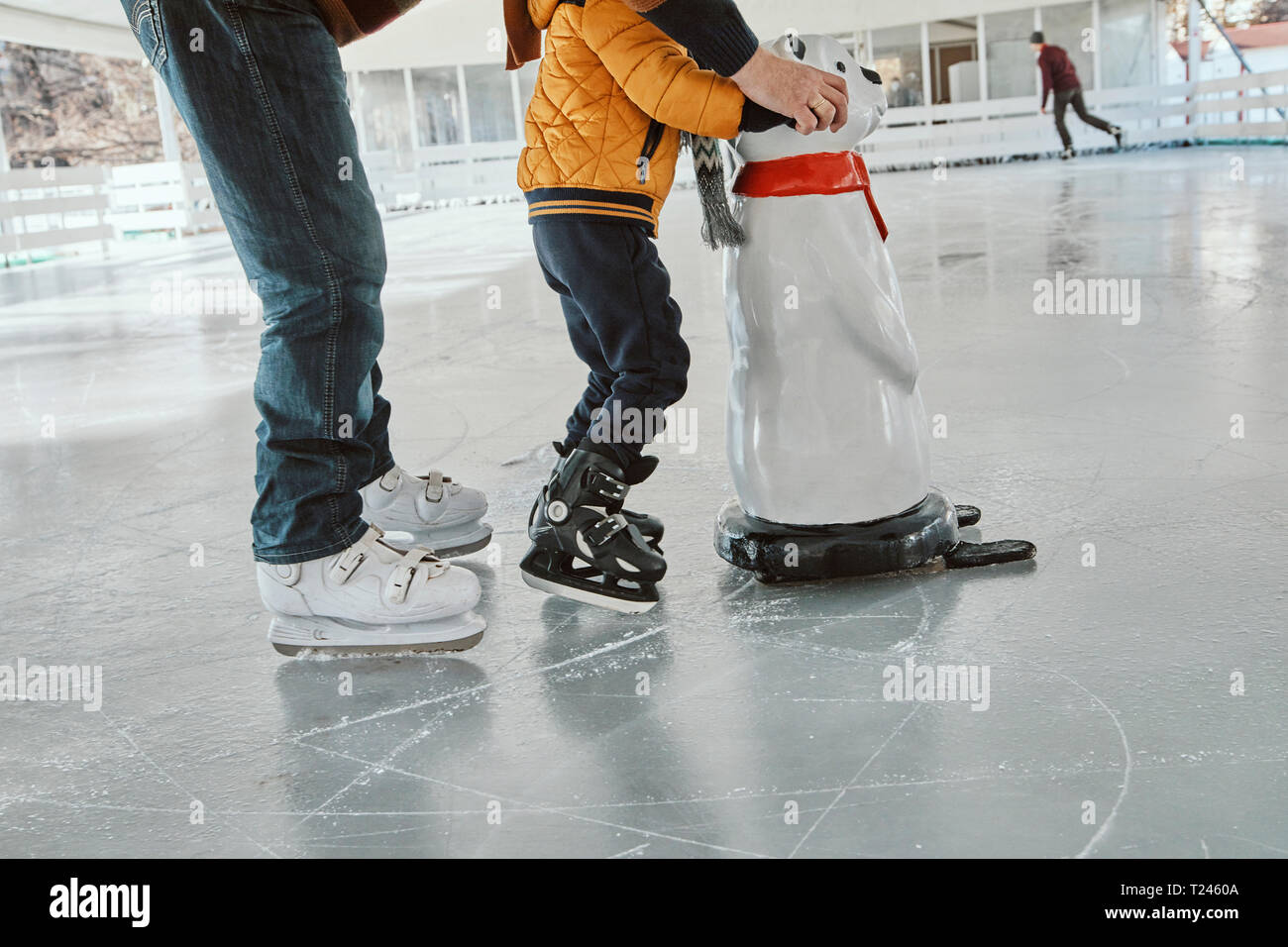 Grandfather and grandson on the ice rink, ice skating, using ice bear ...