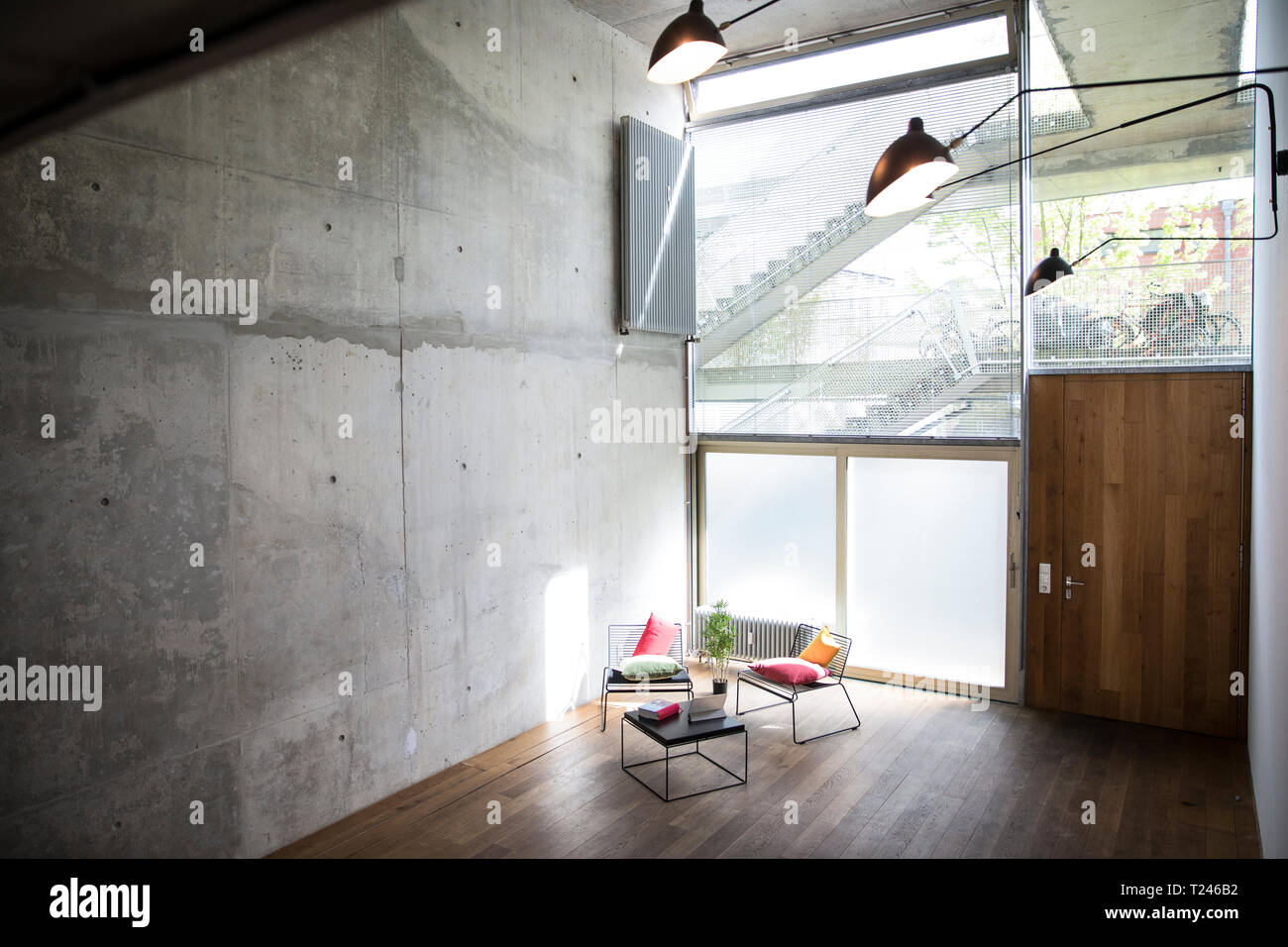 Sitting area in a loft at concrete wall Stock Photo - Alamy