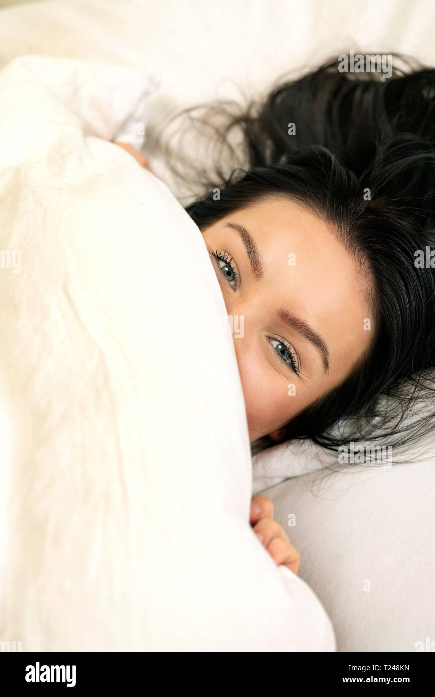 Beautiful woman lying in bed, smiling, portarit Stock Photo - Alamy