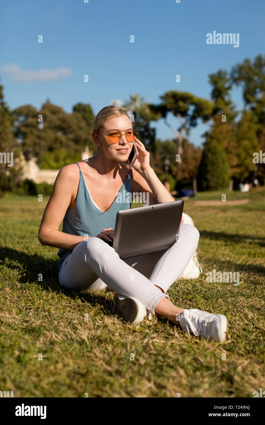 Young woman sitting park hi-res stock photography and images - Alamy