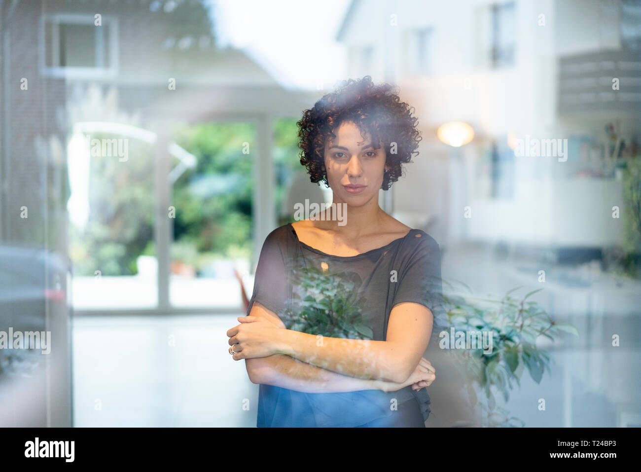 Portrait of woman standing behind window at home Stock Photo - Alamy