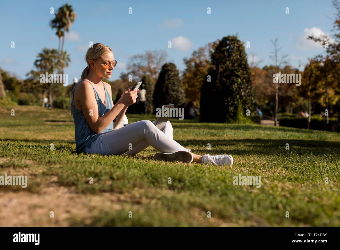 Young woman sitting park hi-res stock photography and images - Alamy